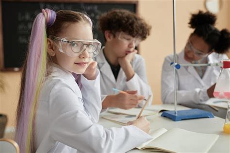 Premium Photo Cute Schoolgirl Enjoying Science Class Looking At Camera