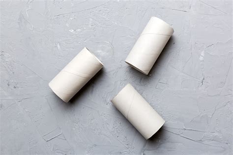 빈 화장지 롤과 컬러 배경에 텍스트를위한 공간이있는 평평한 누워 구성 크래프트 종이 또는 판지로 만든 금속 플러그 끝이있는 재활용 가능한 종이 튜브 0명에 대한 스톡 사진