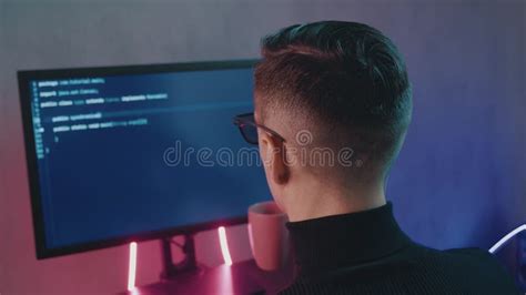 Programmer Coding On A Computer In The Dark With A View Of The Lights