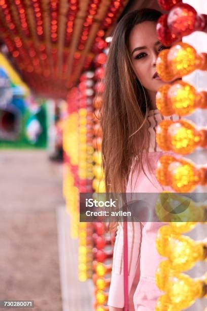 놀이공원에서 조명이 켜진 전구 사이에 서 있는 여성 모델의 초상화 25 29세에 대한 스톡 사진 및 기타 이미지 25 29세 갈색 머리 긴 머리 Istock