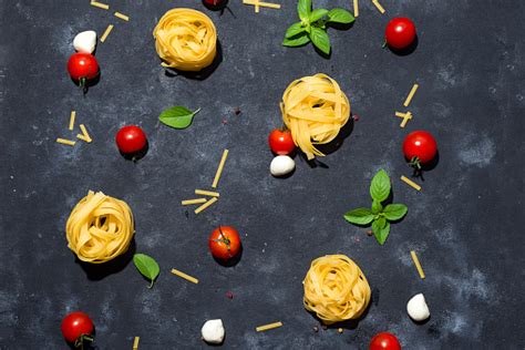 파스타 패턴입니다 건조 파스타와 야채와 어두운 돌 테이블에 허브의 몇 가지 유형 텍스트에 대 한 여유 공간입니다 상위 뷰 강판에