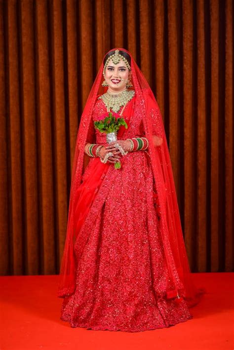 결혼식 복장 결혼식 초상화 꽃다발을 든 신부 남아시아 신부 남아시아 패션 레드와 골드 모델 문화적 문화적 복장 미소 짓는 미소 짓는 신부 방글라데시