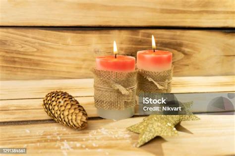 나무 배경에 크리스마스 촛불 필드의 얕은 깊이 두 개의 빨간 촛불이 반짝이는 크리스마스 별과 전나무 원뿔 옆에 자루 밧줄로 싸여 있습니다 0명에 대한 스톡 사진 및 기타