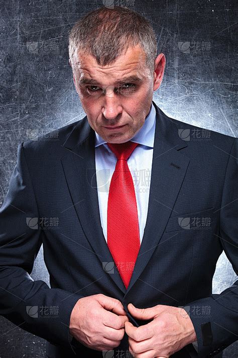 戏剧性的严肃的成熟的商人解开他的外套