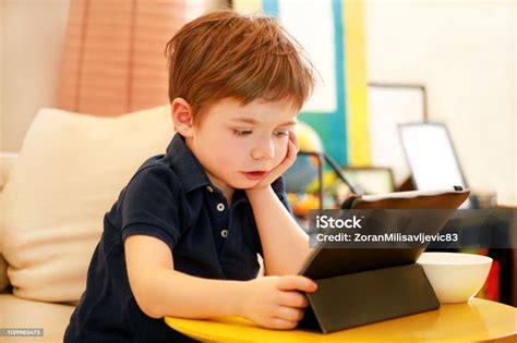 가정에서 침대에 태블릿 Pc를 사용 하는 아이 소파에 귀여운 소년은 만화를 보고 게임을 재생 하 고 노트북에서 학습 교육 재미