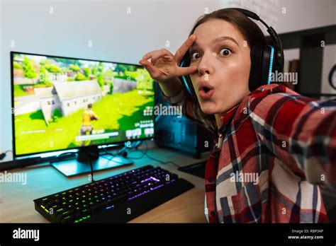Excited Girl Gamer Sitting At The Table Playing Online Games On A