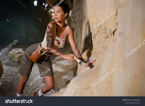Sexy Tattooed Archaeologist Holding Brush Near Stock Photo
