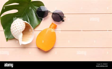 Sea Shell Sunscreen Cream Tropical Leaf And Sunglasses On Wooden