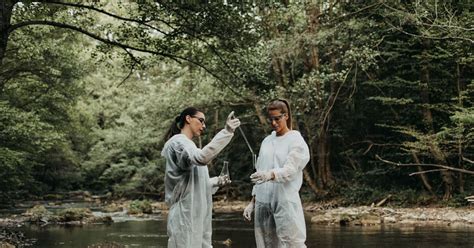 보호 복을 입은 과학자 생물 학자와 연구원이 오염 된 강에서 물 샘플을 채취합니다 사진 Unsplash의 자연 이미지