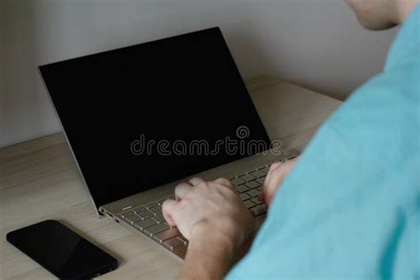 Close Up Mans Hands Programming On Laptop And Smartphone Lying Near By