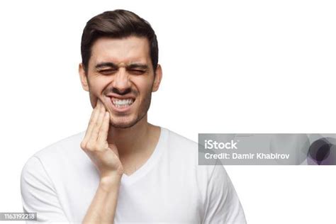 치아 통증 고통을 느끼고 한 손으로 뺨을 잡고 나쁜 치통으로 고통받고 고통스러운 표정을 지니고 흰색 배경에 고립되어 있습니다 T 셔츠에 대한 스톡 사진 및 기타 이미지