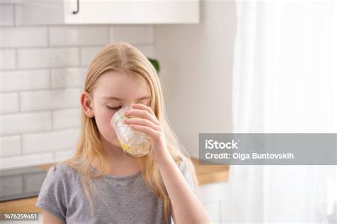 소녀는 밝은 부엌의 배경에 유리에서 레몬과 민트로 물을 마 십니다 레몬에 대한 스톡 사진 및 기타 이미지 레몬 아이 쥠 Istock