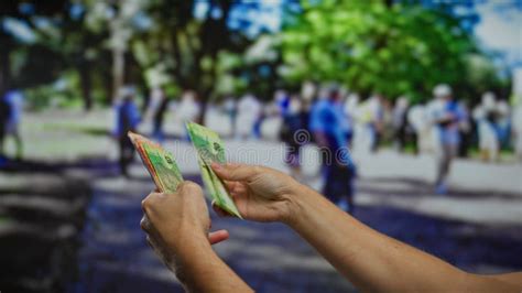 Man Counting South African Rand Banknotes Outdoors With Blurred City Park Background And Diverse