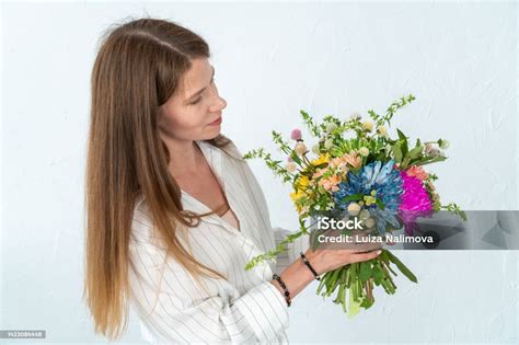 긴 머리카락을 가진 소녀 플로리스트의 초상화는 국화의 꽃다발을 선물합니다 직장에서 플로리스트 교육 마스터 클래스 꽃집 과정 35 39세에 대한 스톡 사진 및 기타 이미지