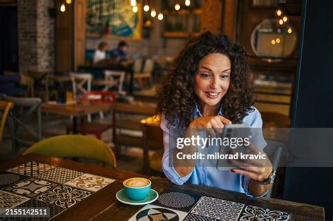 A Curly Hair Mature Women Enjoy In Cafe She Drinking Coffee And Using