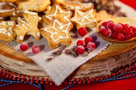 나무 숟가락에 신선한 열매가있는 크리스마스 진저 브레드 쿠키는 나무 위에 붉은 배경 넓은 깊이의 필드 선택적 초점에 있습니다 크리스마스와 새해 개념 12월에 대한 스톡 사진