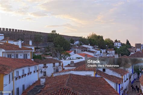 화이트의 아름 다운 보기 빨간 기와 지붕 집 그리고 요새의 벽에서 Obidos의 성입니다 석양에 중세 건축으로 아름 다운 오래 된 도시 거리에 대한 스톡 사진 및 기타