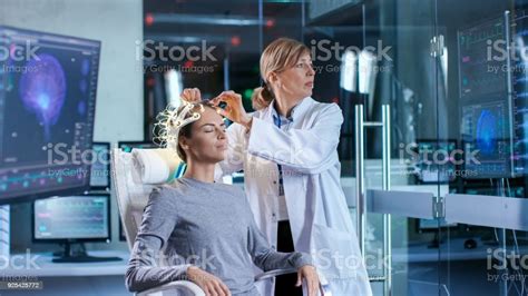 여자 착용 브레인 웨이브 스캔 헤드셋 앉아 과학자 조정 하는 동안의 자에는 장치 디스플레이에 보인다 에 현대 뇌 연구 실험실 모니터 표시 Eeg 독서 및 뇌 모델입니다 뇌