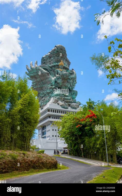The Statue Of Lord Wishnu Against The Backdrop Of A Cloudy Blue Sky At The Garuda Wisnu Kencana