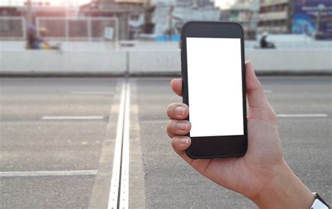 여자는 화면 스마트 폰에 손가락을 가리키는 모형 흰색 스마트 폰 빈 디스플레이를 개최 모형 반짝이 거리 라이프 스타일 흐릿한 배경 기업 비즈니스에 대한 스톡 사진 및 기타