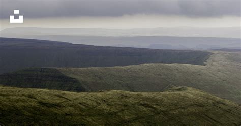푸른 잔디로 덮인 산 하얀 하늘 아래 사진 Unsplash의 무료 풍경 이미지