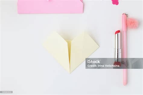 플랫 레이 종이 접기 기법에서 마음의 모양으로 접힌 분홍색 봉투 립스틱 펜 색종이 하트 노란색 종이 발렌타인 데이 엽서 만들기 직접 수행하십시오 시리즈의 사진 0명에 대한