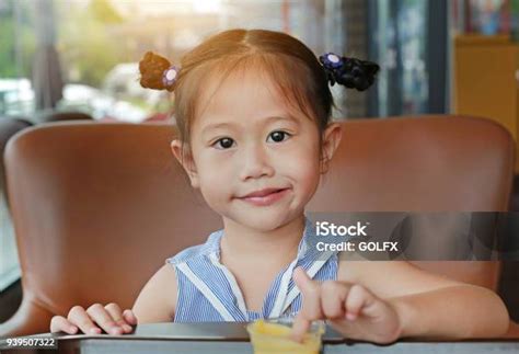 Gadis Kecil Menikmati Makan Saus Manis Di Kafe Makan Dengan Jarinya Foto Stok Unduh Gambar