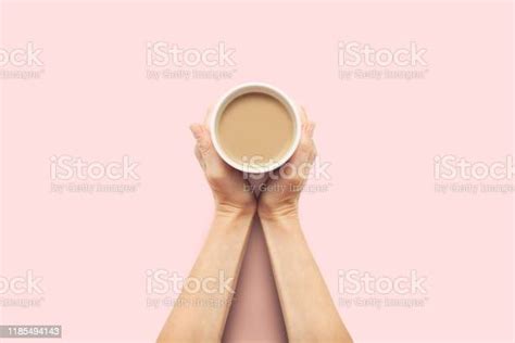 분홍색 배경에 뜨거운 커피와 함께 컵을 들고 두 손 커피 또는 차로 아침 식사 개념 좋은 아침 밤 불면증 플랫 레이 상단 보기