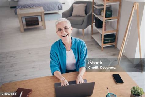 위의 전망 좋은 나이 든 여자의 초상화 노트북 착용 셔츠 현대 인테리어 가정 작업 사무실 평면 실내 55 59세에 대한 스톡
