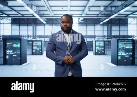 Technician Walking Between Server Rows In Data Center Doing Yearly Infrastructure Inspection