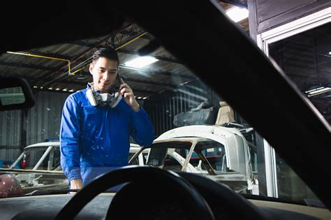 기업가 사업가 중소기업 소유자 차고 자동차 수리점 화가 점프 수트와 먼지 마스크를 착용 차고에 앉아 휴대 전화와 노트북을 사용합니다 30 34세에 대한 스톡 사진 및 기타