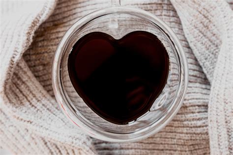 베이지 색 구겨진 침대 직물에 아늑한 분위기에서 심장 모양의 더블 바닥컵 침대에서 아늑한 집에서 만든 게으른 아침 식사를