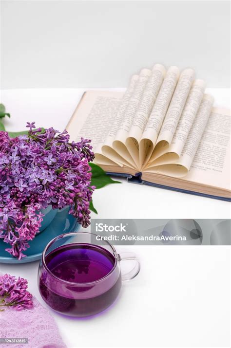 향기로운 보라색 클리토리아 차 한 잔과 파란색 컵에 라일락 꽃다발 흰색 배경에 열린 책 선택적 초점 낭만적 인 개념 수평 배경 복사 공간 5월에 대한 스톡 사진 및 기타