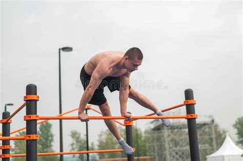 A Shirtless Man Is Doing A Workout On The Horizontal Bars Outdoors Stock Image Image Of