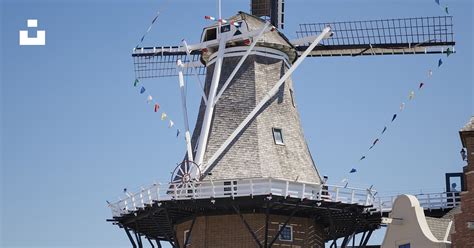 풍차 옆 거리를 걷고 있는 한 무리의 사람들 사진 Unsplash의 무료 펠라 이미지