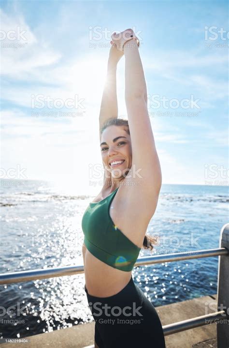 피트니스 여성 해변에서 스트레칭 바디를 하며 야외에서 요가 운동 또는 유산소 운동을 합니다 자연에서 운동이나 훈련을 위해 미소를 지으며 팔을 뻗는 워밍업 여성 러너의 초상화