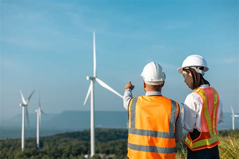 풍차 농장에서 일하는 두 명의 엔지니어 남자와 여자가 전기 청정 에너지를 생성합니다 대체 녹색 에너지에 의한 풍력 터빈 농장 발전기 제어 전력을 확인하는 아시아 엔지니어 2