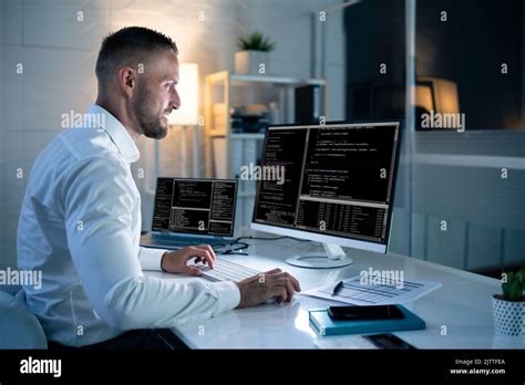 Computer Programmer Writing Program Code On Computer In Office Stock