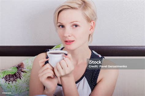 젊은 아름다운 금발의 여자 와 짧은 머리 앉아 에 그녀의 침대 과 보유 A 뜨거운 음료 금발 머리에 대한 스톡 사진 및 기타 이미지 금발 머리 동슬라브족 러시아