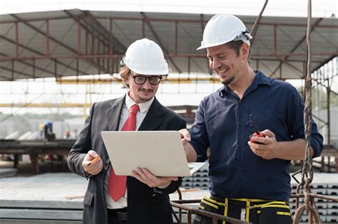 건설 현장에서 프리캐스트 콘크리트 벽 구조 품질에 대해 논의하는 두 명의 감독 건축업자 건설 현장에서 일하는 건설 감독관 그룹