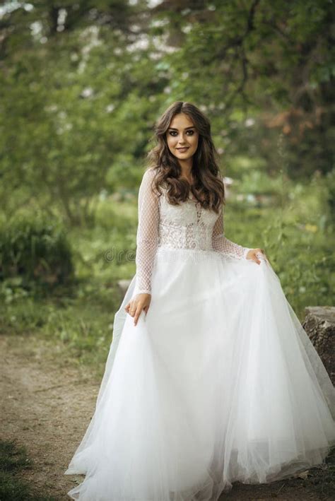 Young Girl Bride In A White Dress In A Spring Forest On A Wedding Day