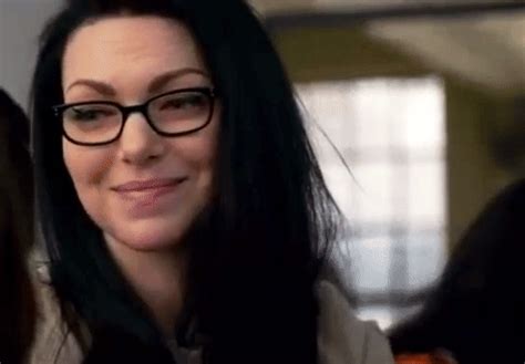 A Woman Wearing Glasses Smiling At The Camera With Other People In The