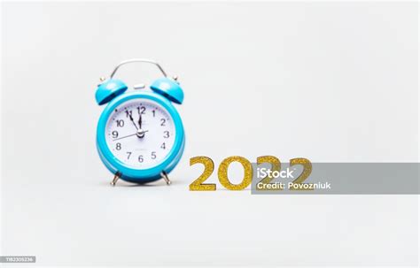 세월이 쏜 살 같다 2022년 황금 인물 근처 중간에 배치 된 5 분에서 12 분까지의 청록색 시계의 클로즈업 사진 0명에 대한