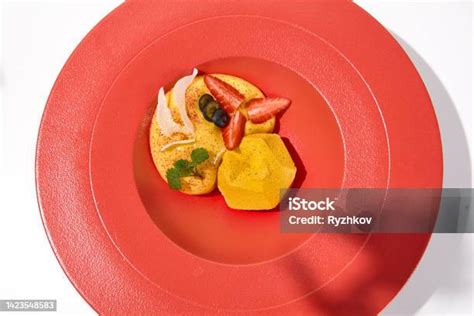 흰색 배경에 현대적인 스타일의 노란색 무스 케이크 망고 무스와 열매를 곁들인 열정 과일 케이크 레스토랑 접시에 열정 과일을 곁들인 요구르트 케이크 라이트 무스 디저트 무스