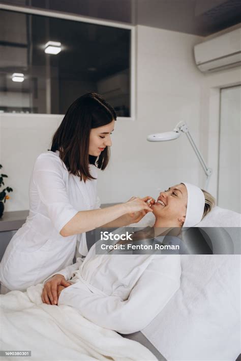 미소 리프팅 및 입술 확대 미용사 의사는 주사기로 여성의 얼굴에 미용 시술을 하고 있다 필러 주사로 세는 젊은 여성의 입 꼭두각시 라인 치료 25 29세에 대한 스톡 사진