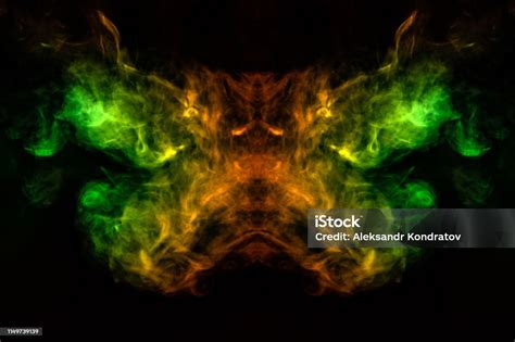 검은 고립 된 배경에 날개와 머리 얼굴과 눈의 모양에 공포의 형태로 다른 녹색 노란색 오렌지와 붉은 색의 연기 신비한 상징의 영혼과 유령 0명에 대한 스톡 사진 및 기타