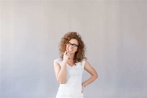 가로 총 긍정적인 다행 유럽 여자의 매력적인 모습 매력적인 미소 사려깊은 교활한 표정 옆으로 보이는 회색 배경 위에 캐주얼 세련 된 Redhair 학생 여자 경영자에 대한