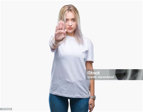 중지 하 고 격리 된 배경 위에 젊은 금발 여자는 손의 종 려를 가진 노래 얼굴에 부정적이 고 심각한 제스처와 경고 식입니다