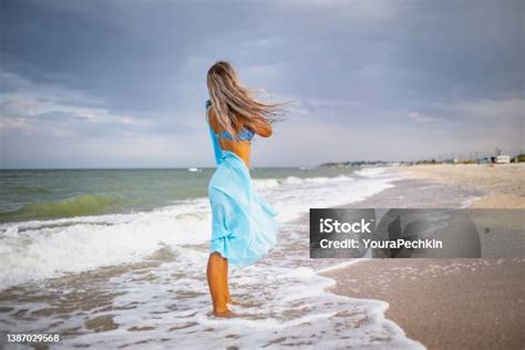 푸른 색 수영복을 입은 금발 머리를 한 소녀와 해변을 따라 걷는 밝은 목도리를 입은 소녀 가냘픈에 대한 스톡 사진 및 기타 이미지 가냘픈 건강한 생활방식 걷기