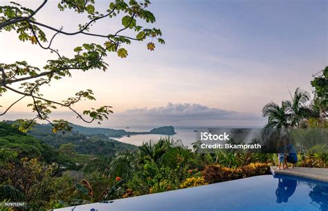 코스타리카 태평양 연안의 마누엘 안토니오 국립공원의 야생의 길들여지지 않은 해안 아름다움 위로 활기찬 일출을 즐기는 아버지와